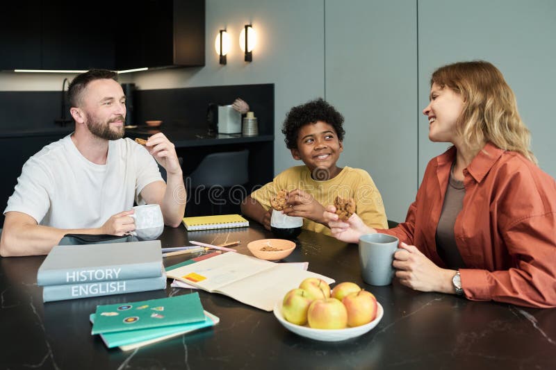 Family Sharing Breakfast and Smiling Around Kitchen Table Stock Image ...