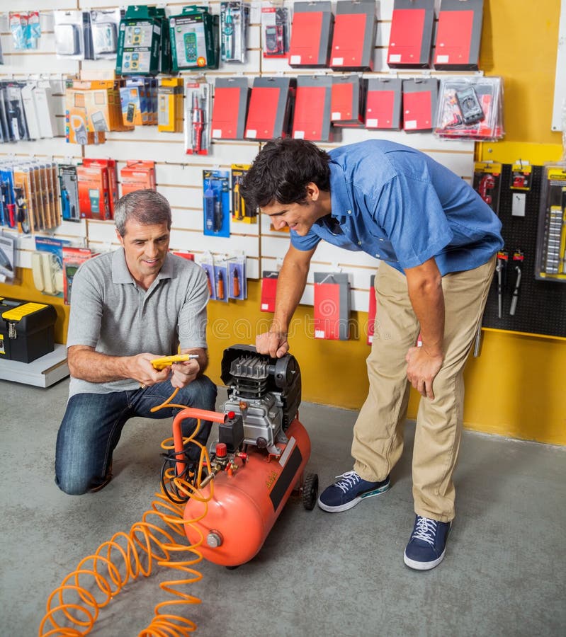 Family Examining Air Compressor in Store Stock Photo - Image of male ...