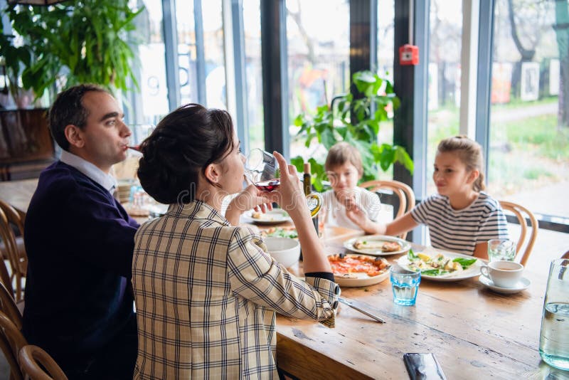 A Family of Four Having a Dinner in a Cafe Stock Image - Image of ...