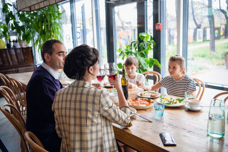 A Family of Four Raising Glasses at Dinner in a Cafe Stock Photo ...
