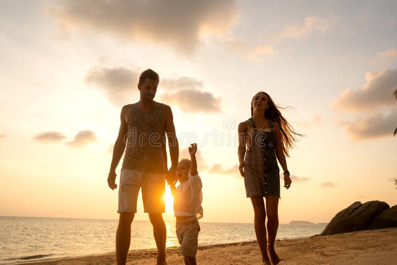Family Happily Walk Along a Tropical Beach at Sunset Stock Image ...