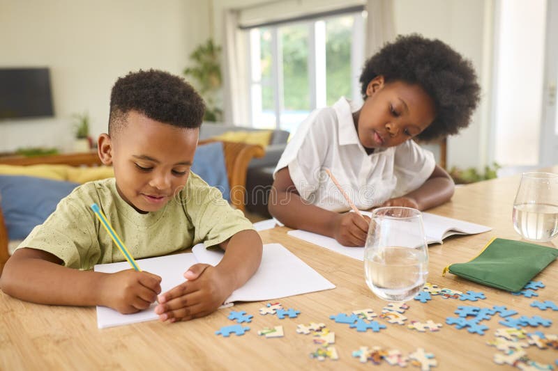 Family Indoors at Home with Children Doing Homework Sitting at Table ...