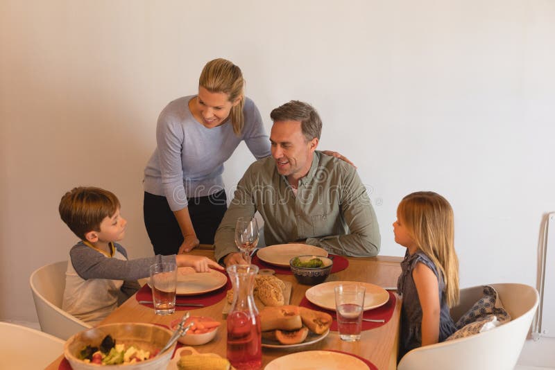 Family Interacting with Each Other while Having Meal on Dining Table ...