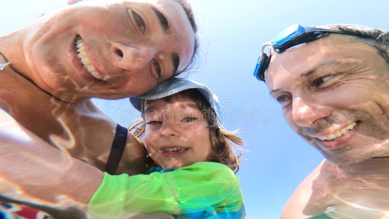 Family with Kid Having Fun. Distorted Faces View through Water ...