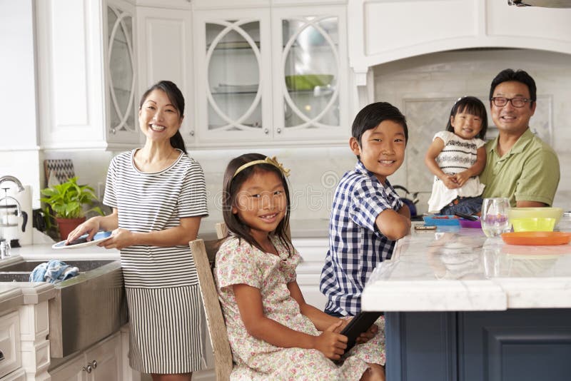 Family in Kitchen Doing Chores and Using Digital Devices Stock Image ...