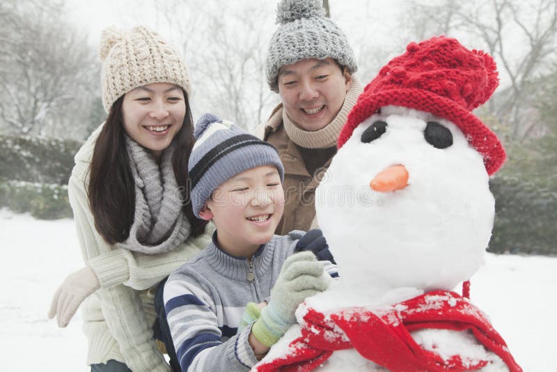 Group of Friends Building Snowman on Ski Holiday Stock Photo - Image of ...