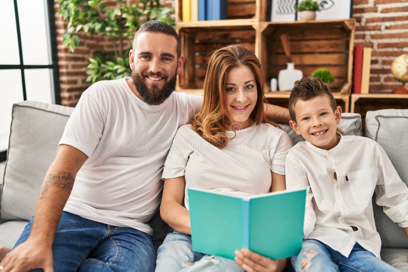 Family Reading Book Sitting on Sofa at Home Stock Image - Image of ...