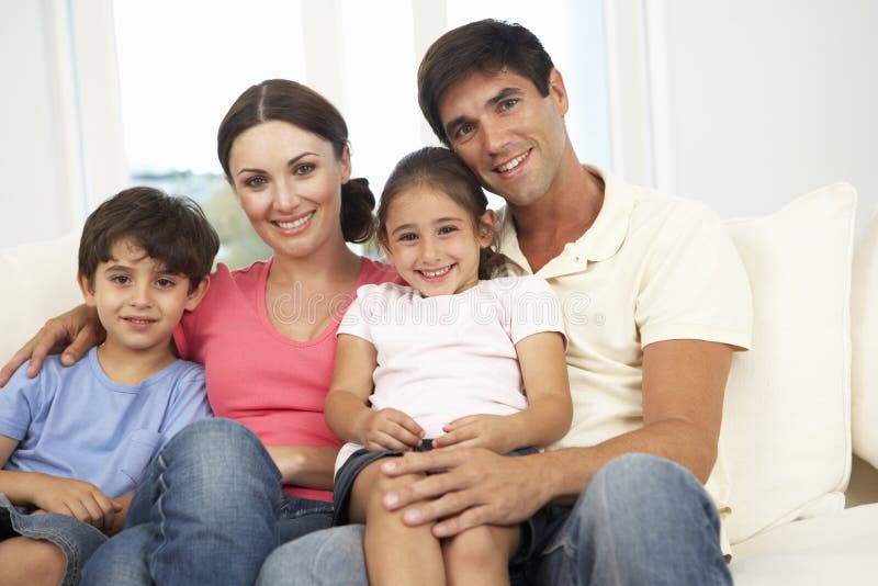 Family Relaxing on Sofa at Home Together Stock Photo - Image of indoors ...