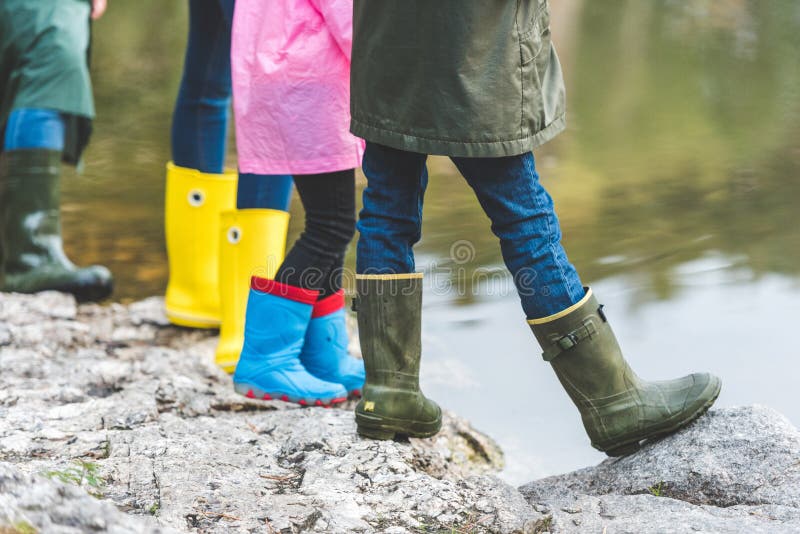 Family in Rubber Boots Standing on Rock Stock Image - Image of children ...