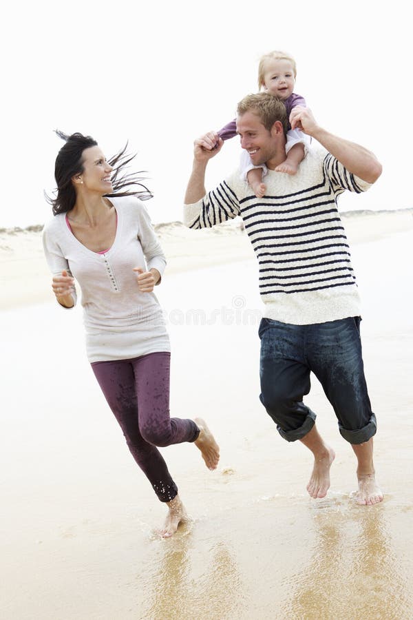 Family Running Along Beach Together Stock Image - Image of mother, male ...