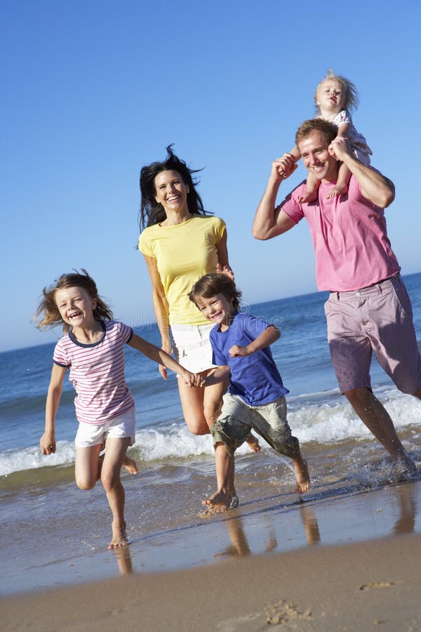 Family Running Along Beach Together Stock Image - Image of thirties ...