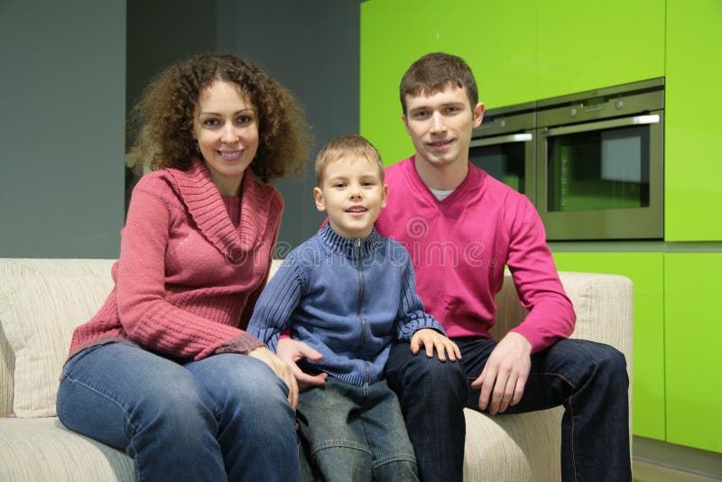 Family sits on sofa stock photo. Image of male, jeans - 5225278