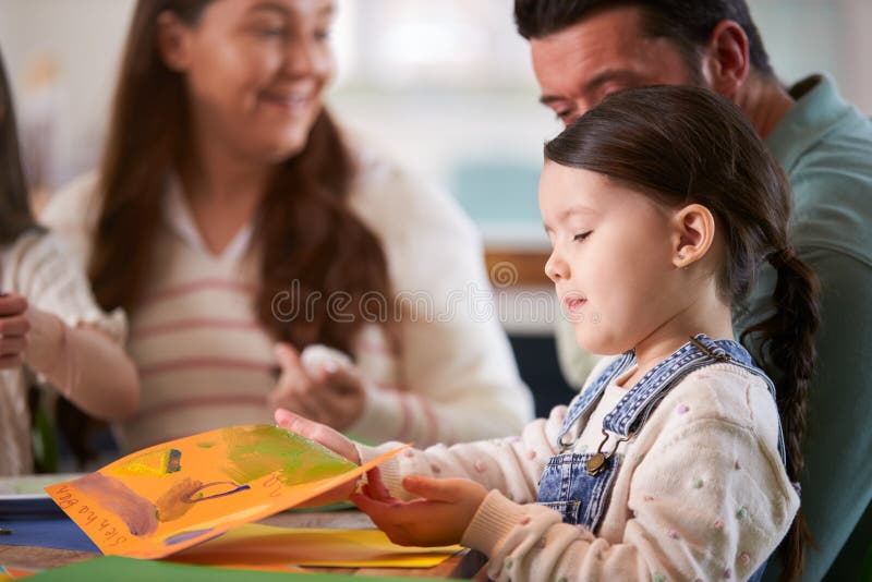 Family Sitting Around Table at Home Doing Craft Together Stock Image ...