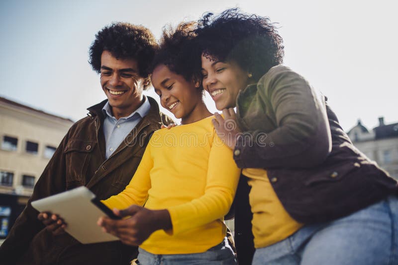 Family Sitting on Bench, Relaxing Using Gadget, Browsing Internet Stock ...