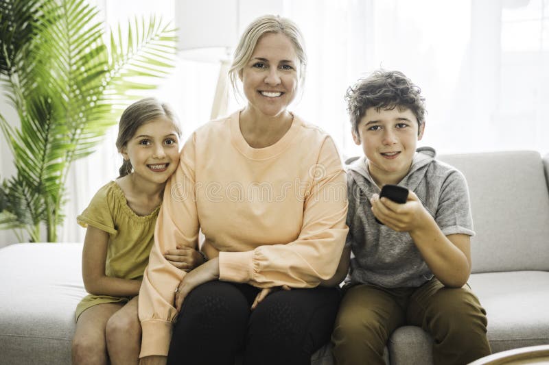 Family Sitting on the Couch Using a Remote Control Stock Photo - Image ...