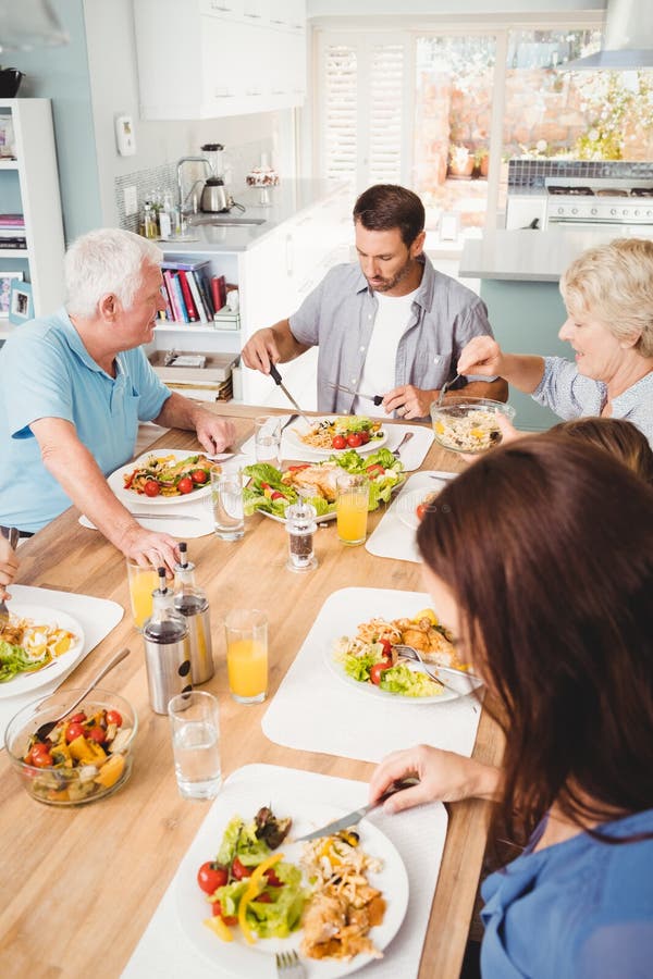 Family Sitting at Dining Table Stock Photo - Image of home, generation ...