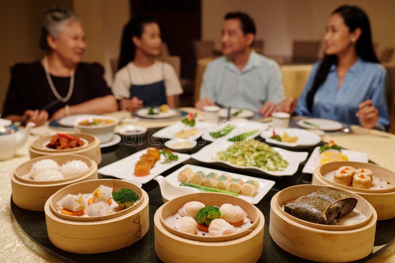 Family Sitting at Dining Table with Various Dishes Stock Photo - Image ...