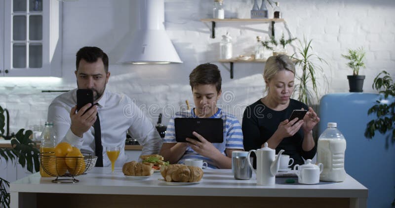 Family Sitting at the Kitchen Table Stock Video - Video of technology ...