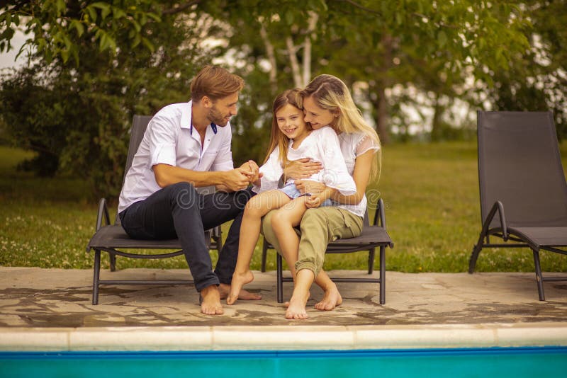 Family sitting by the pool stock photo. Image of ethnicity - 217957712