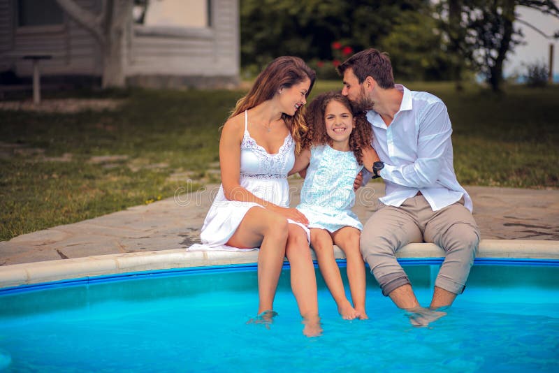 Family sitting by the pool stock photo. Image of happy - 218500418