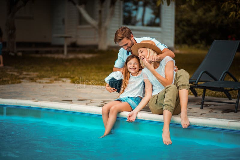 Family Sitting by the Swimming Pool Stock Image - Image of brother ...