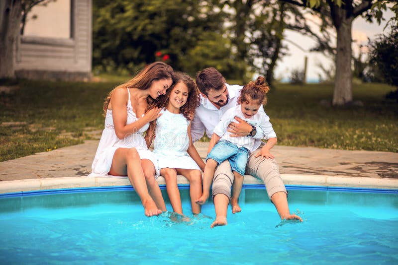 Family sitting by the pool stock image. Image of girls - 219180131