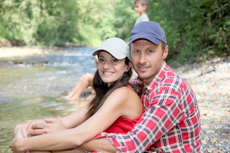 Family sitting by a river stock image. Image of caucasian - 16281913