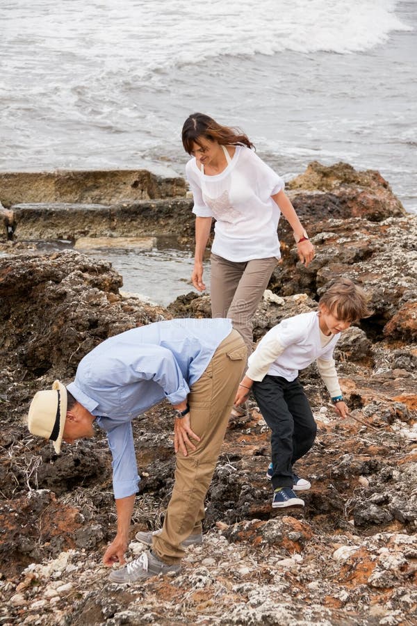 Family Sitting on Rock and Watching the Ocean Stock Image - Image of ...
