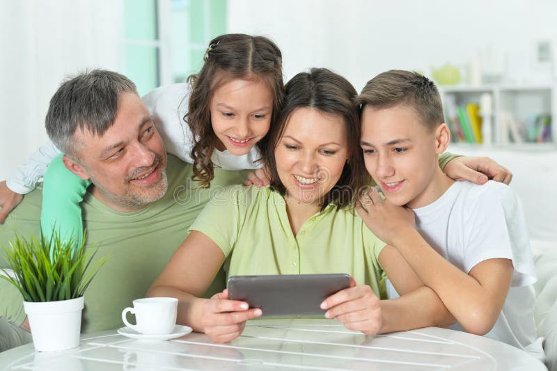 Family Sitting at Table with Tablet Stock Photo - Image of cute ...