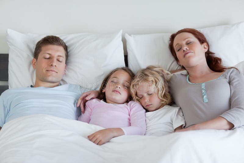 Family Sleeping in the Bed Together Stock Image - Image of indoors ...