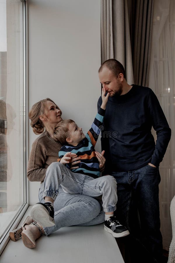 Family with a Small Kid at Home on the Windowsills Spending Time ...