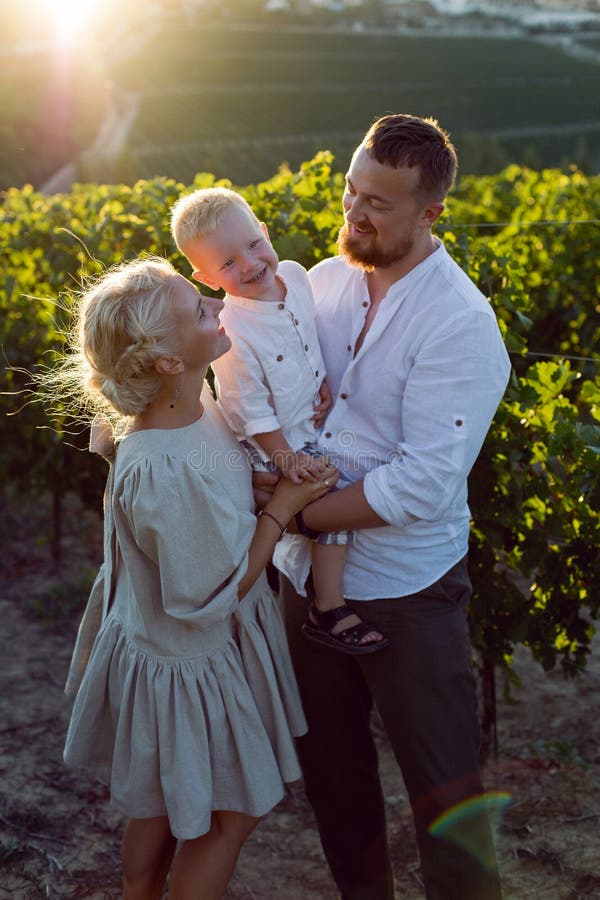 Family of Three in Light Clothes Stand in a Grape Field Stock Image ...