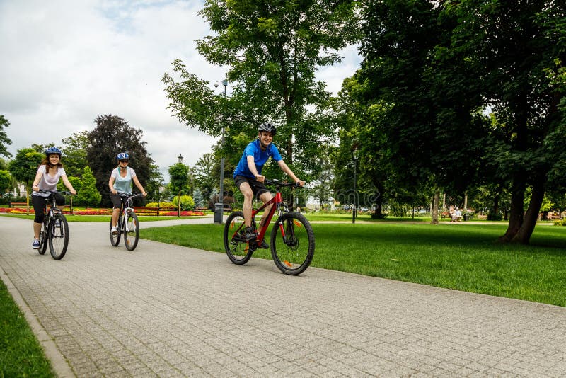 Family of Three People Riding Bikes in Summer Park Stock Image - Image ...
