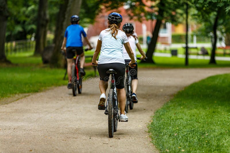 Family of Three People Riding Bikes in Summer Park Stock Image - Image ...
