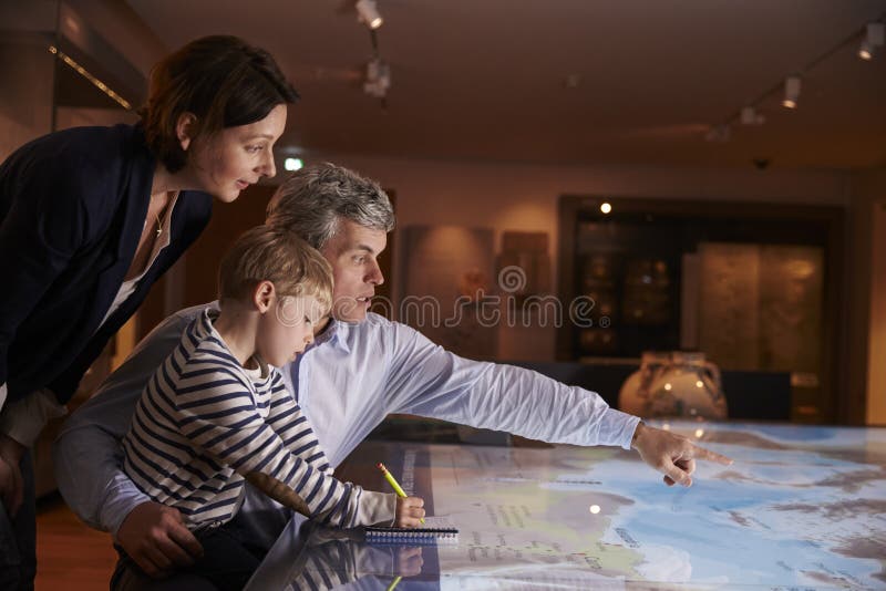 Family on Trip To Museum Looking at Map Together Stock Photo - Image of ...