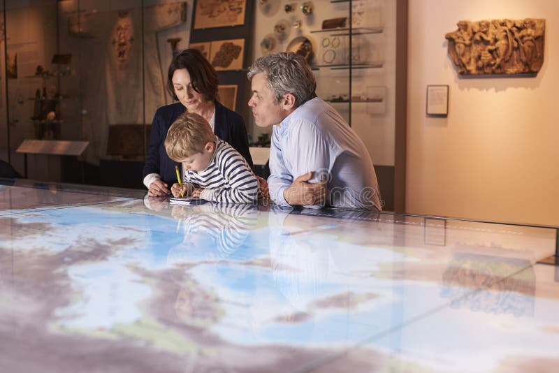 Family on Trip To Museum Looking at Map Together Stock Photo - Image of ...