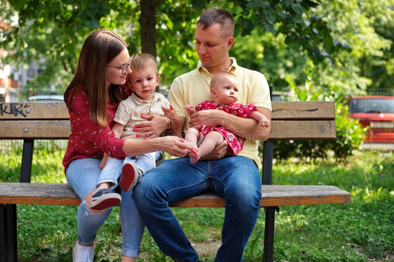 Family Sitting on a Bench in a Park Stock Photo - Image of innocence ...