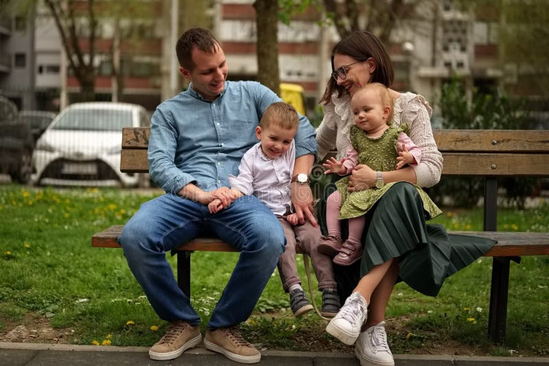 Family with Two Children Sitting on a Bench Stock Image - Image of ...