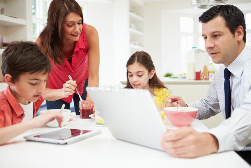 Family Using Gadgets Whilst Eating Breakfast Stock Image - Image of ...