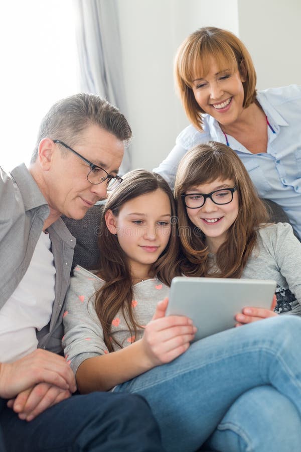 Family Using Digital Tablet Together in Living Room Stock Photo - Image ...