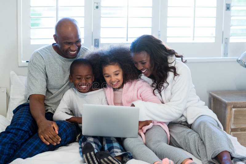 Family using laptop on bed stock photo. Image of family - 78674218