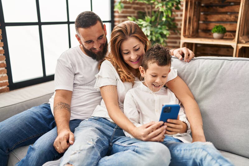 Family Using Smartphone Hugging Each Other Sitting on Sofa at Home ...