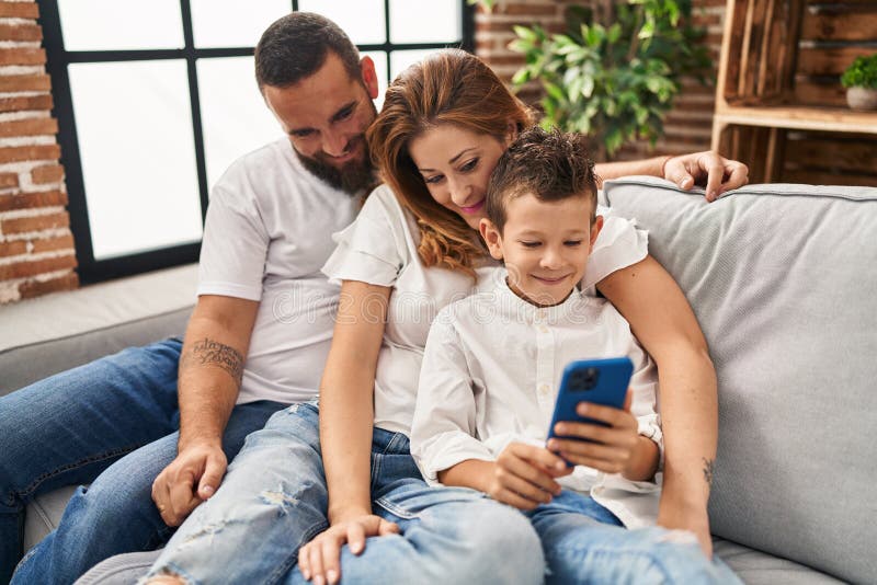 Family Using Smartphone Hugging Each Other Sitting on Sofa at Home ...