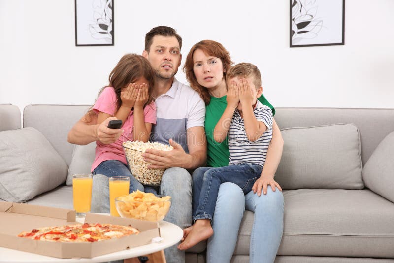 Family with Remote Control Sitting on Couch and Watching TV at Home ...