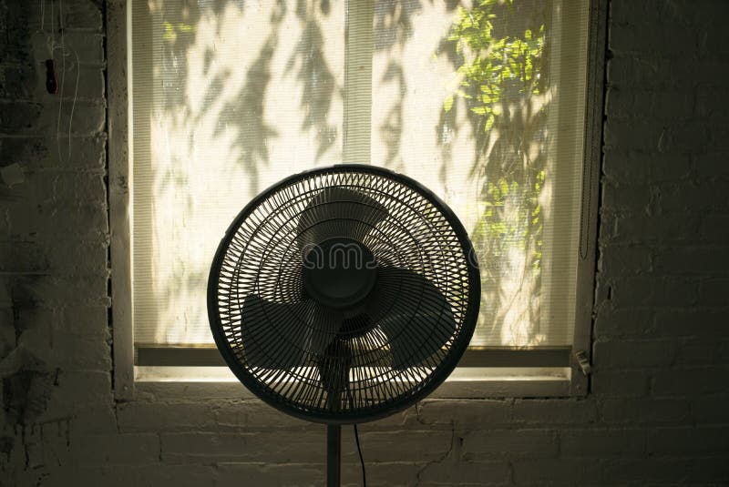 Fan against backlit window stock photo. Image of metal - 55093492