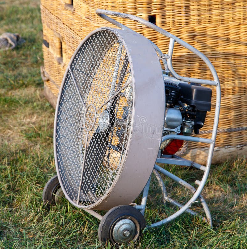 A Fan is Sitting on the Grass Next To a Basket Stock Image - Image of ...