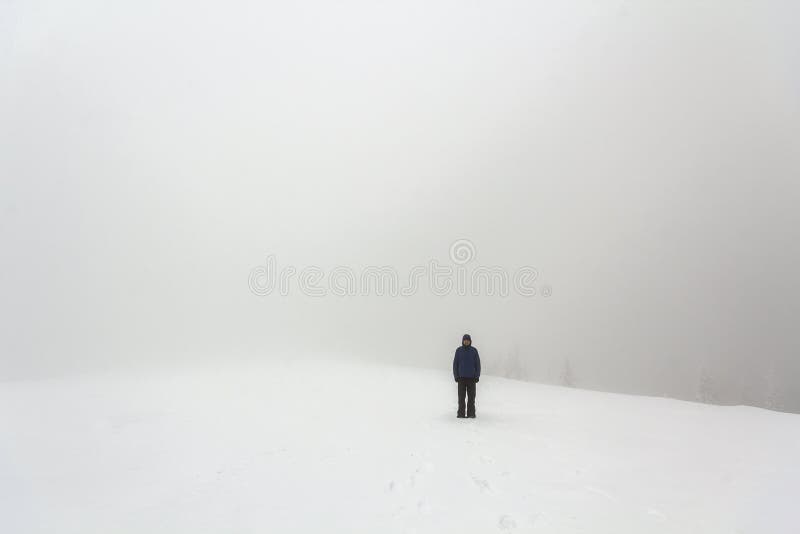 Far Away Lonely Figure of a Man Standing Outdoors in Winter Stock Photo ...