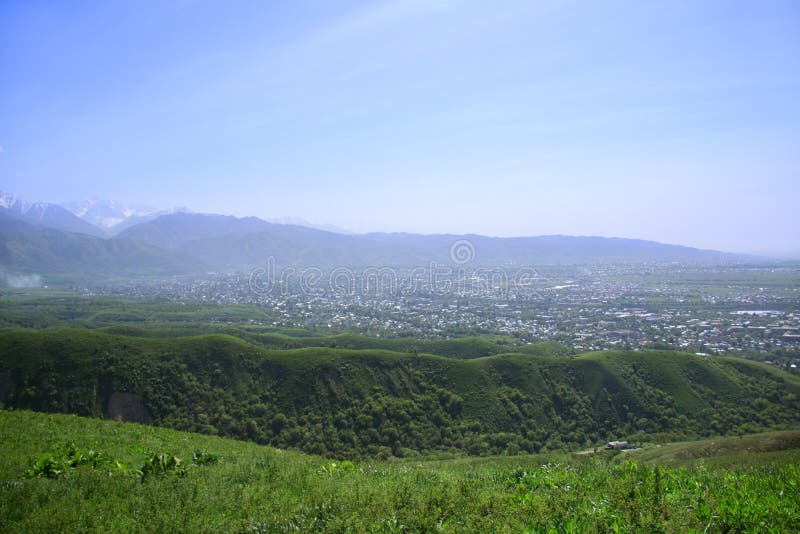 Far View of a High Mountain Range with Green Hills and a Settlement at ...