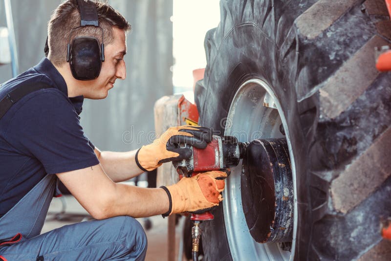 Farm Machine Mechanic Working on Wheel Stock Photo - Image of ...