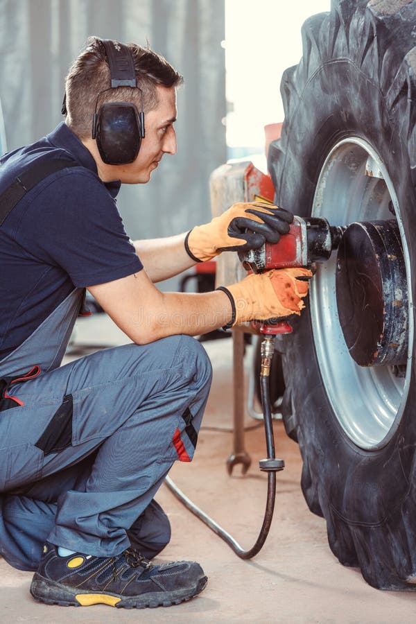 Farm Machine Mechanic Working on Wheel Stock Image - Image of machine ...